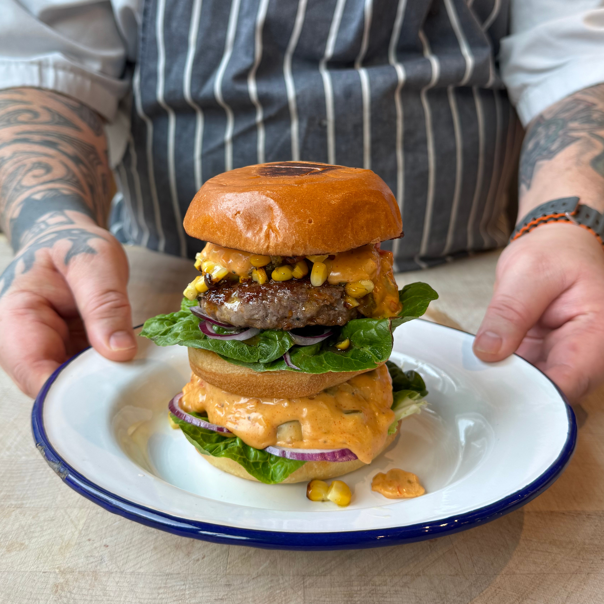 Double Stack Maverick Burger with queso, charred corn salsa, onion & t ...